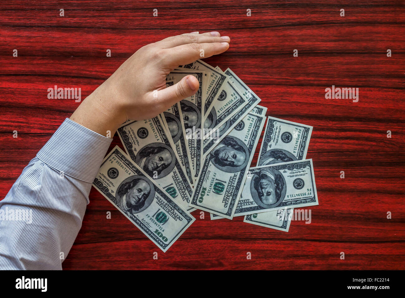 Hands grabbing money from a desk Stock Photo - Alamy