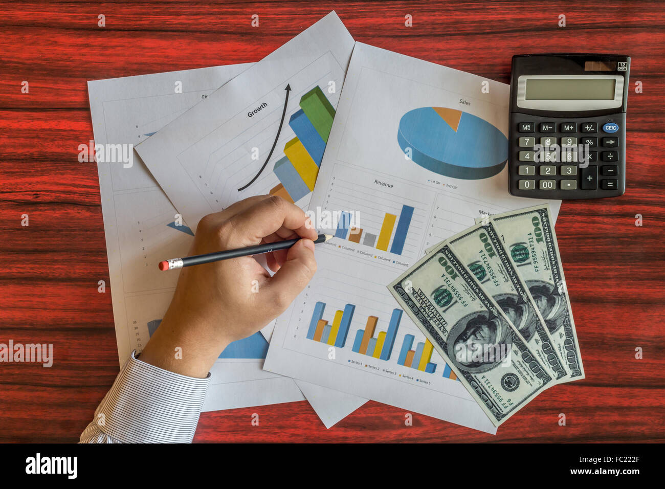 Left handed person analyzing charts Stock Photo - Alamy