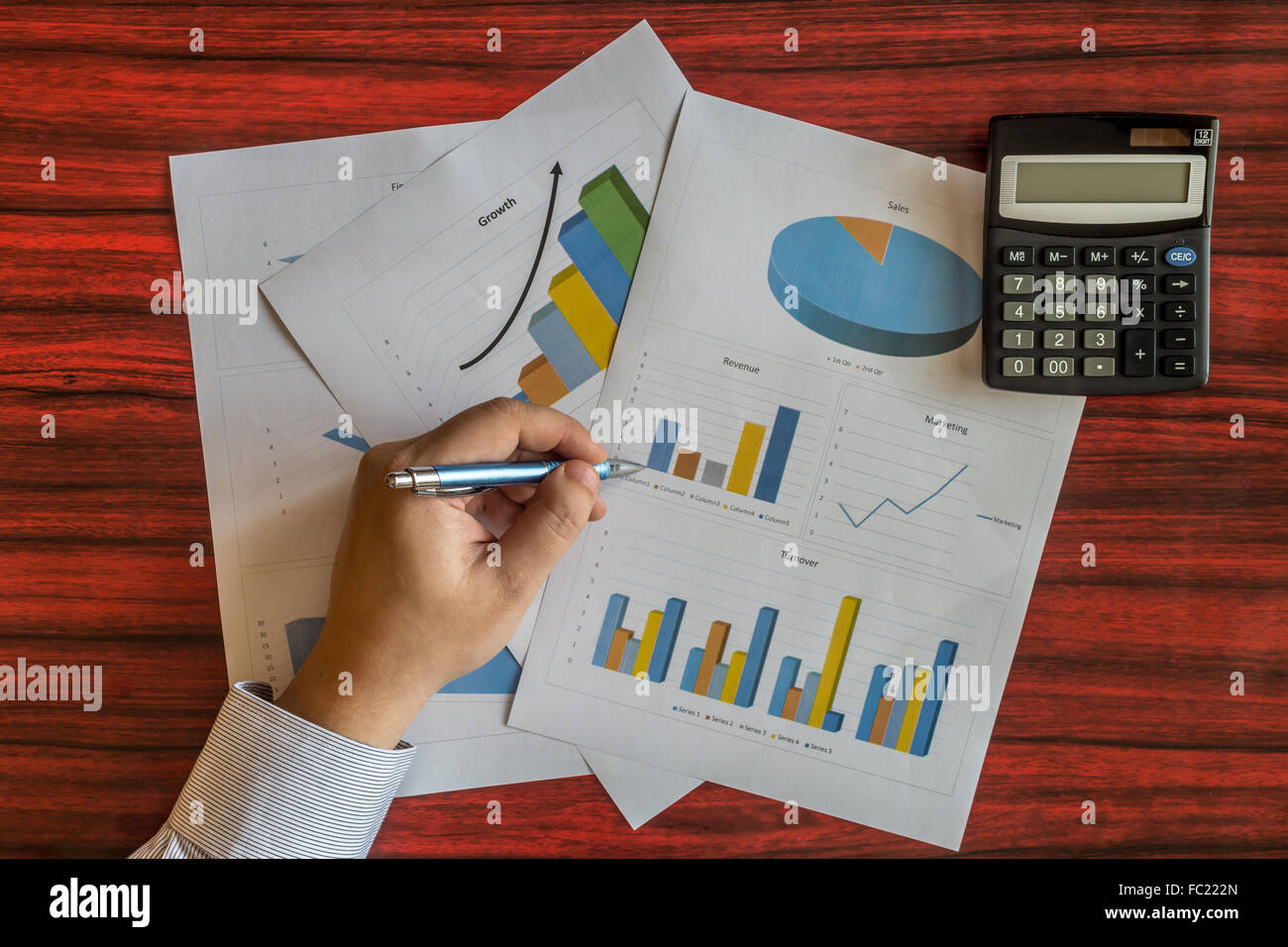 Left handed person analyzing charts Stock Photo - Alamy