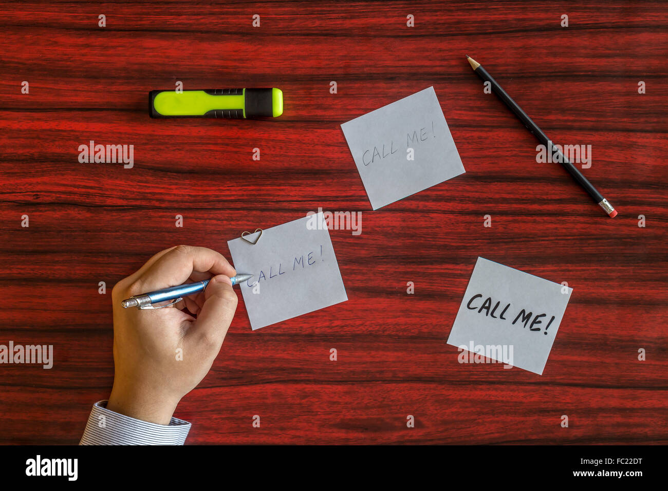 Left handed person writing Call me on a note Stock Photo - Alamy