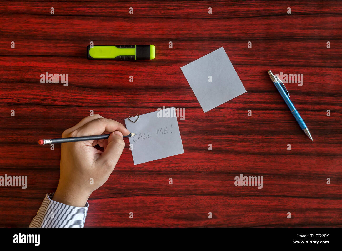 Left handed person writing Call me on a note Stock Photo - Alamy