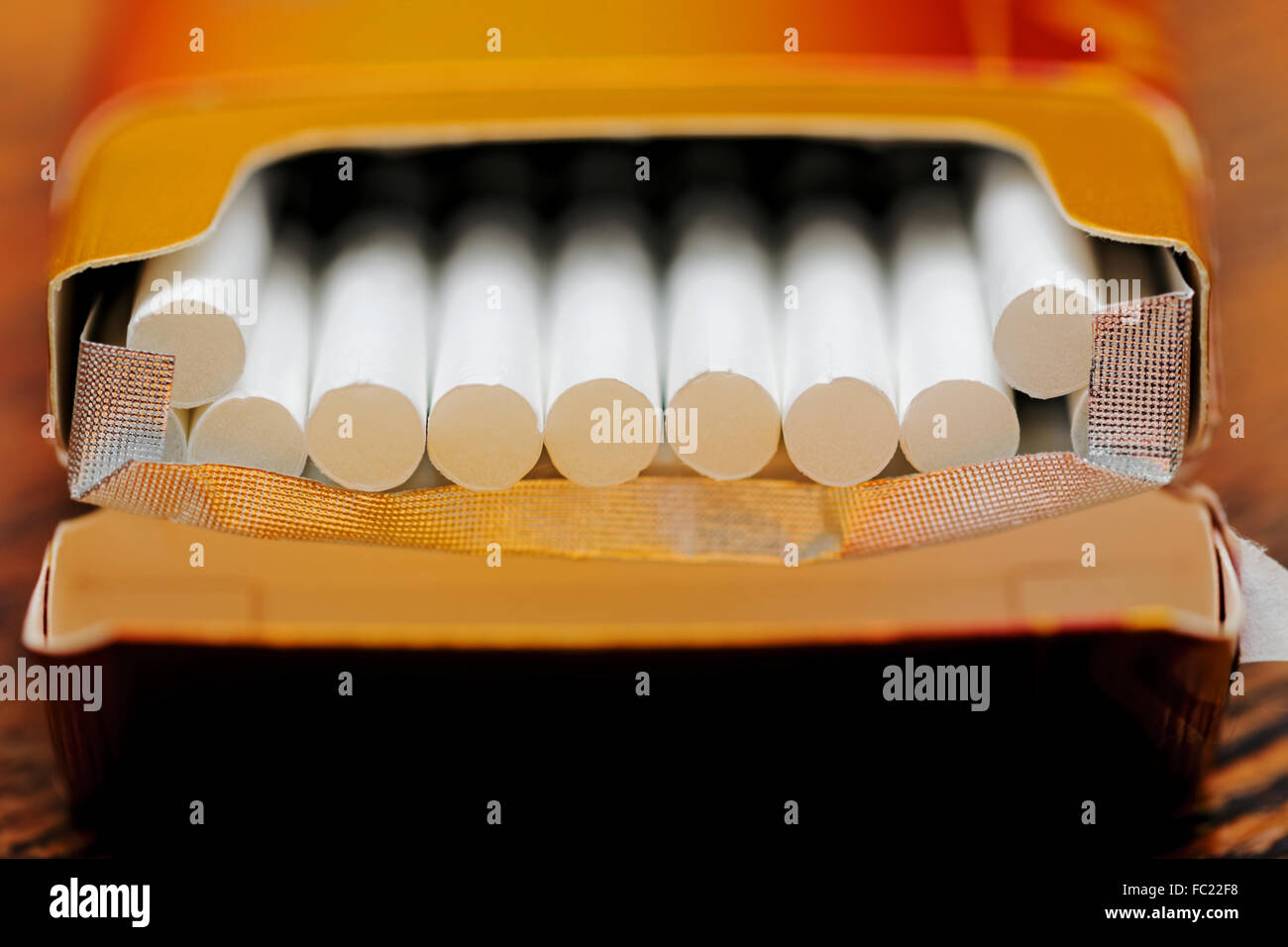 Cigarettes in orange bundle for nice smoking Stock Photo - Alamy