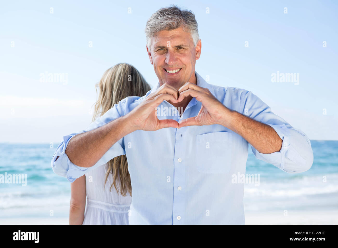 Smiling man doing heart shape with his hands Stock Photo - Alamy