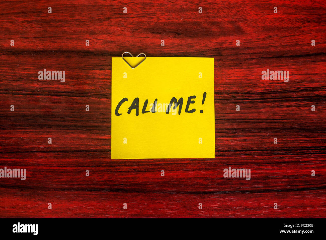 Heart shaped paper clip on a yellow sticky note with the words Call me ...