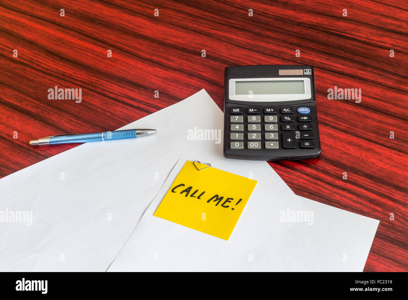 Yellow note with the words Call me written on it. The note is attached ...