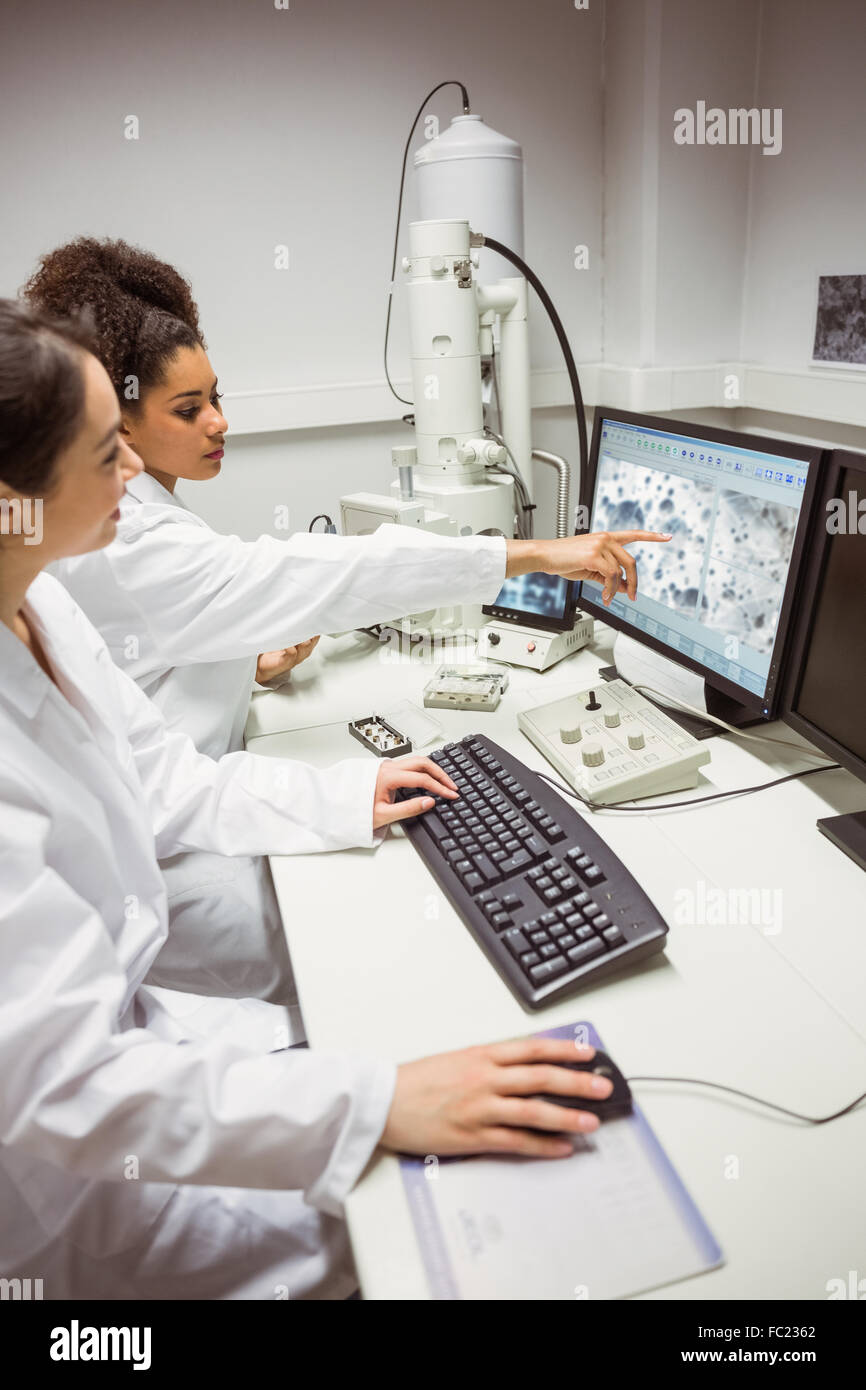 Science students looking at microscopic image on computer Stock Photo ...