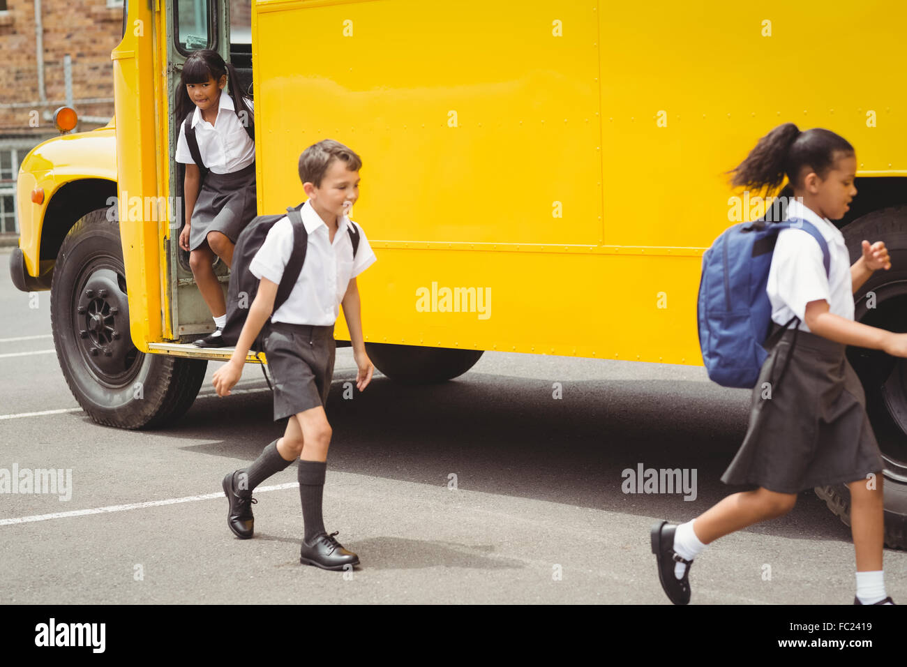 Cute schoolchildren getting off the school bus Stock Photo - Alamy