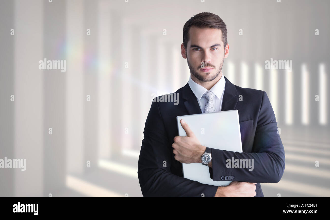 Composite image of businessman in suit posing with his laptop Stock ...