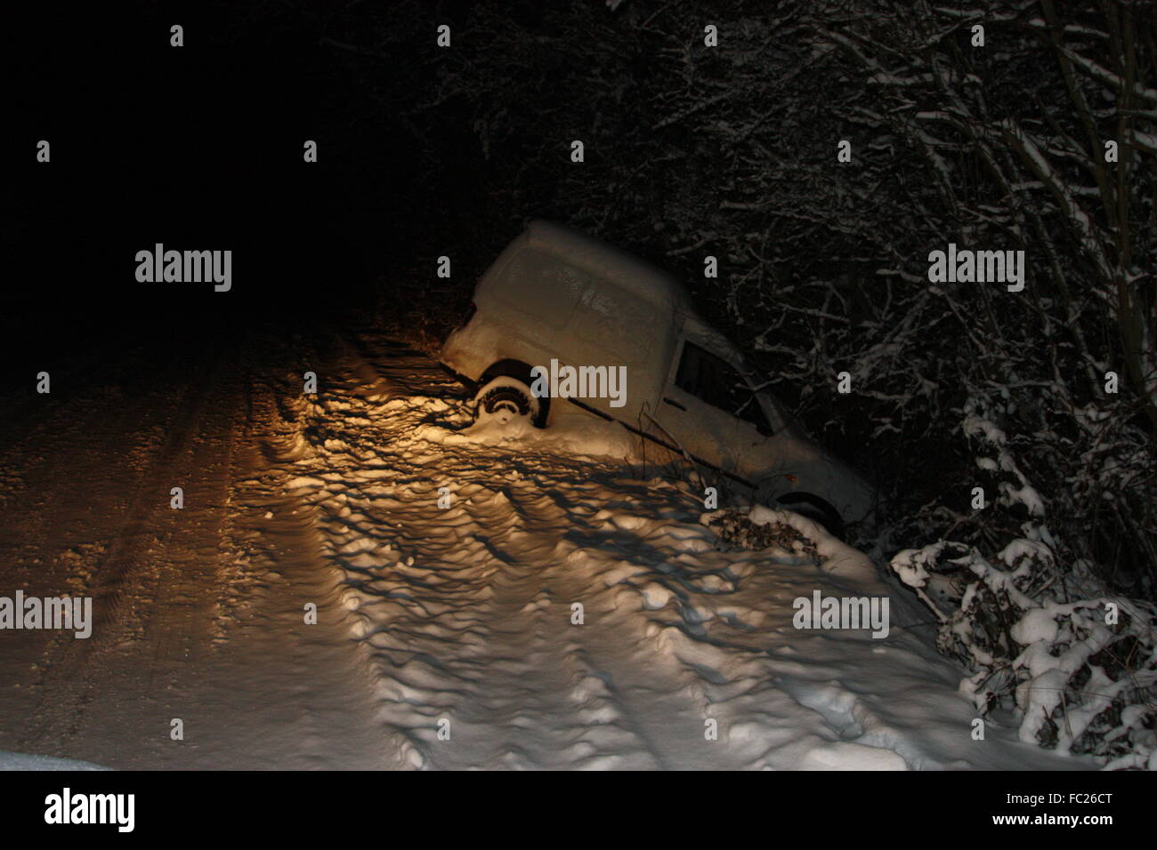 A van skidded into a ditch on a snowy night caught in the headlights on ...
