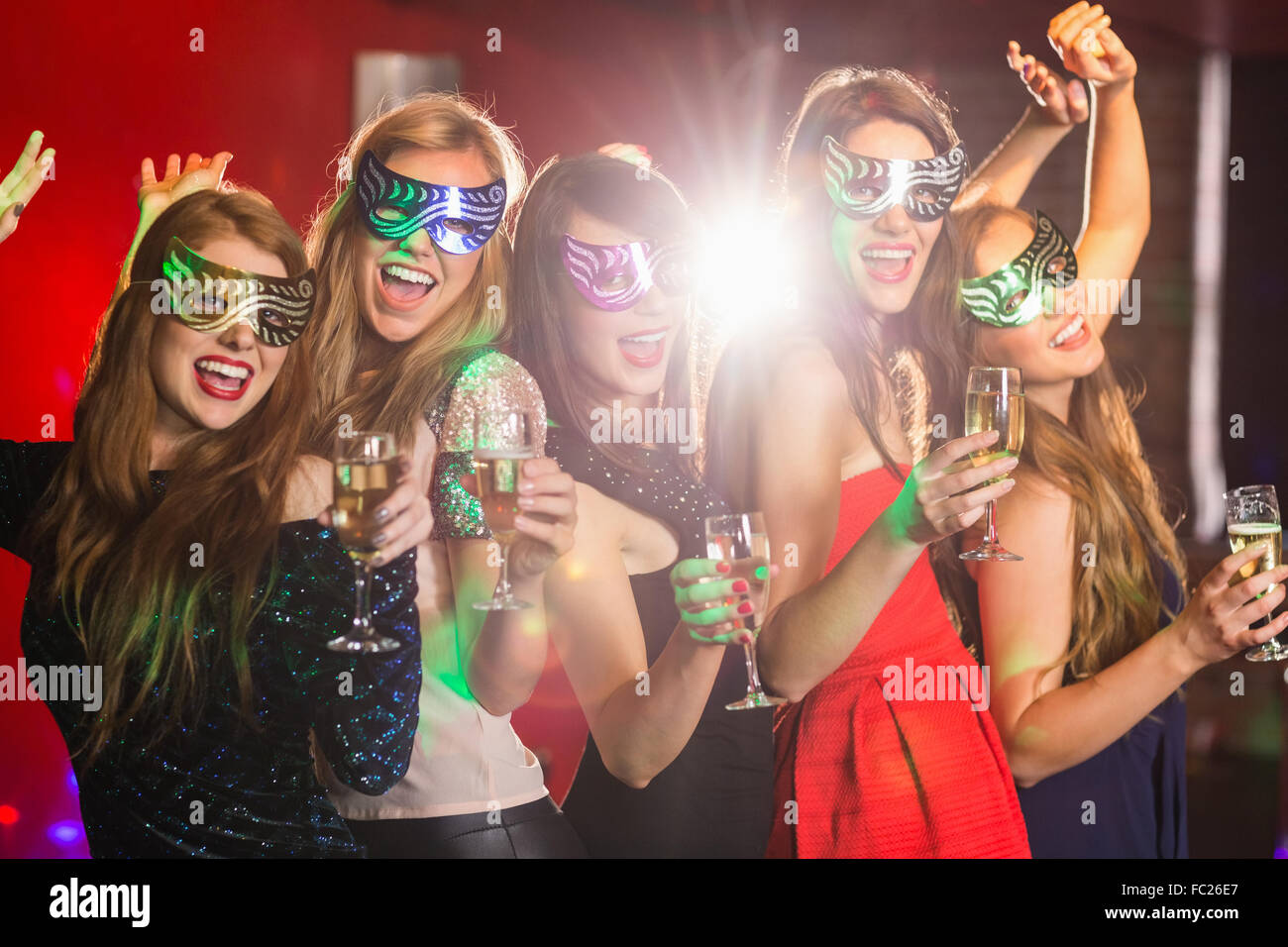 Friends in masquerade masks drinking champagne Stock Photo - Alamy