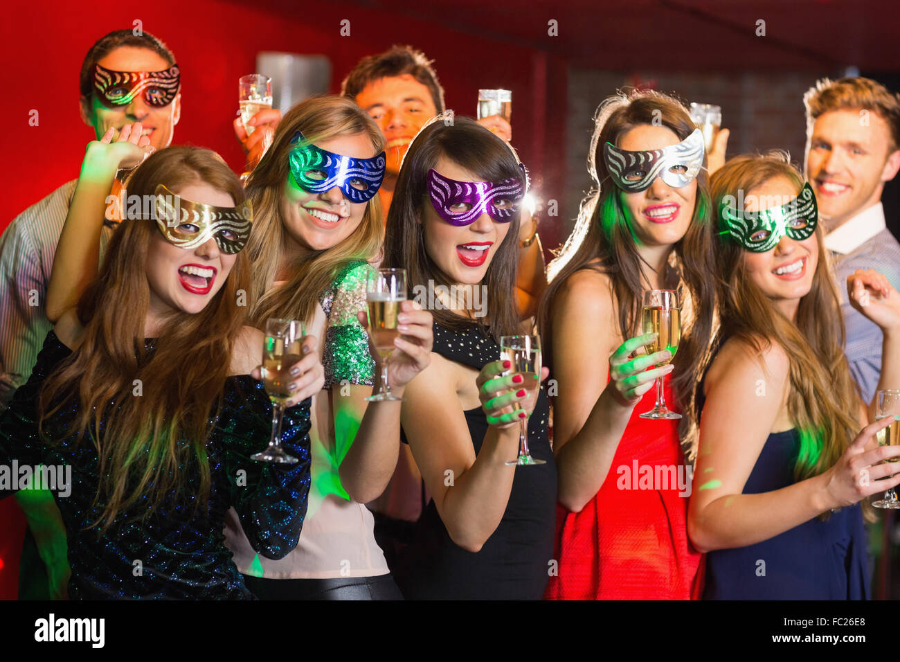 Friends in masquerade masks drinking champagne Stock Photo - Alamy