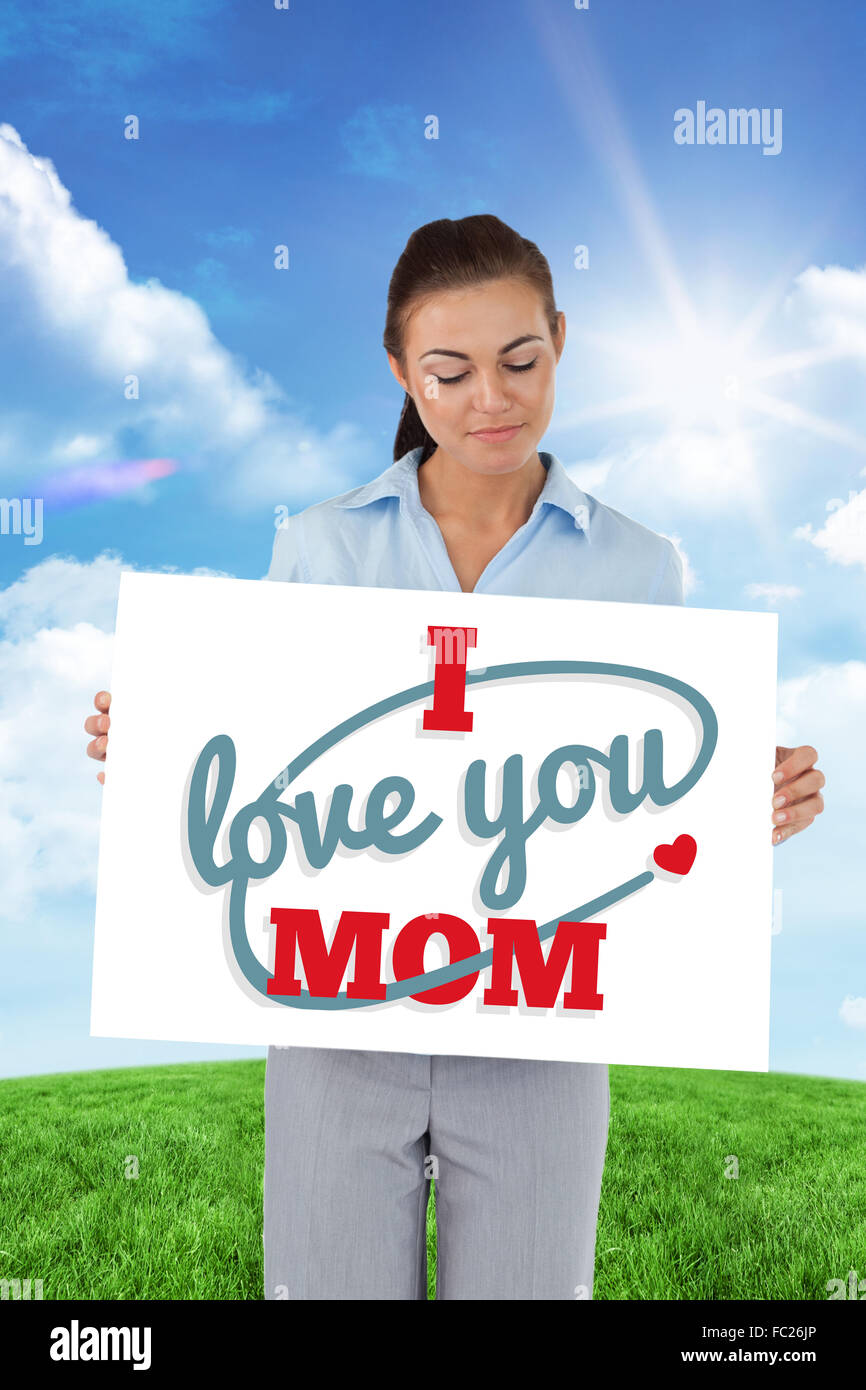 Composite image of businesswoman looking at the sign she is presenting ...