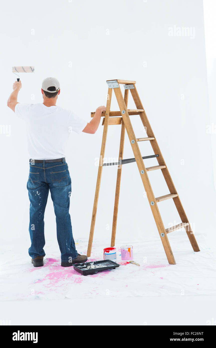 Man painting by step ladder on white background Stock Photo - Alamy