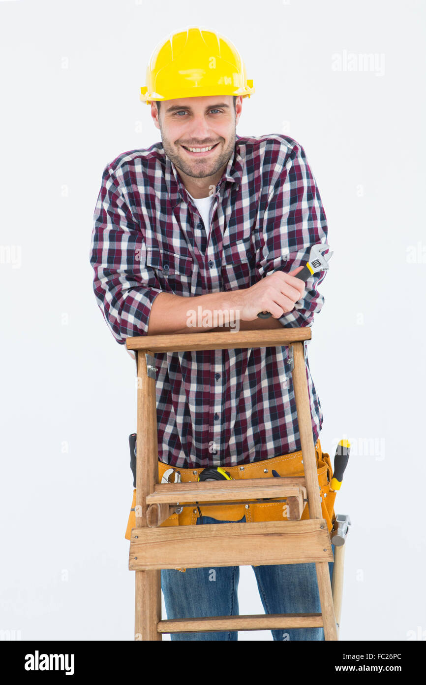 Repairman holding spanner while climbing ladder Stock Photo - Alamy