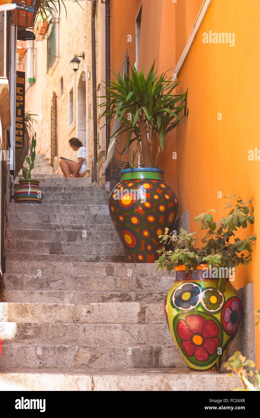Man reading alone, view of a man reading a book in a narrow street in ...