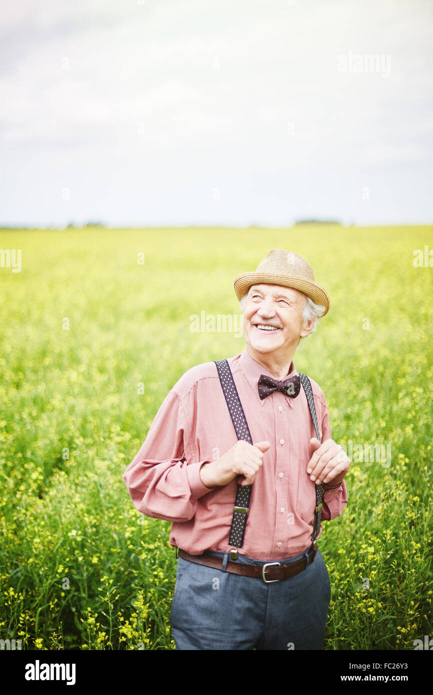 Cheerful senior man standing in meadow Stock Photo - Alamy
