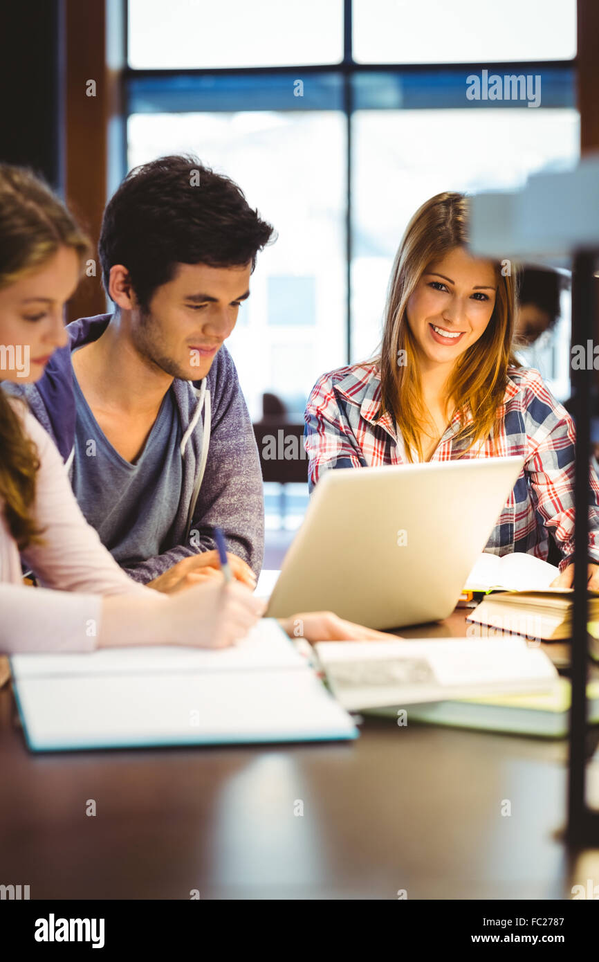 Student looking at camera while studying with classmates Stock Photo ...