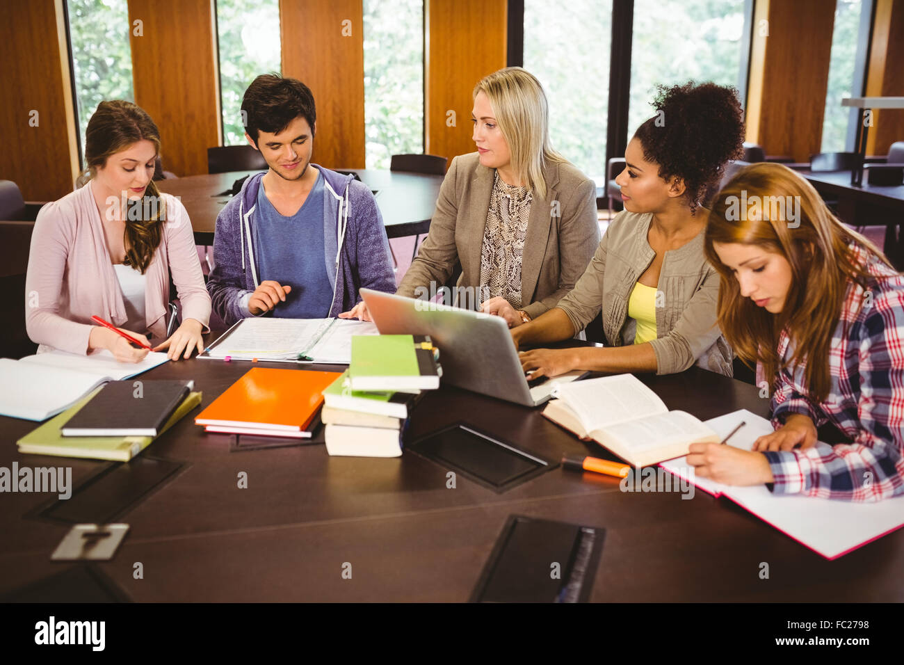 Smiling students working together on an assignment Stock Photo - Alamy