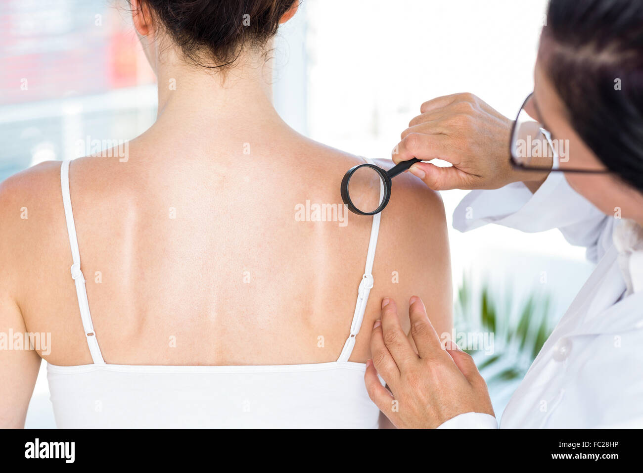 Doctor examining patient with magnifying glass Stock Photo - Alamy