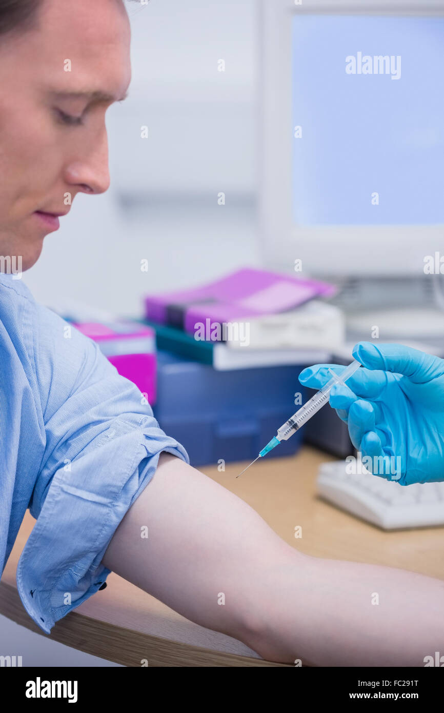 Doctor about doing an injection to the patient arm Stock Photo - Alamy