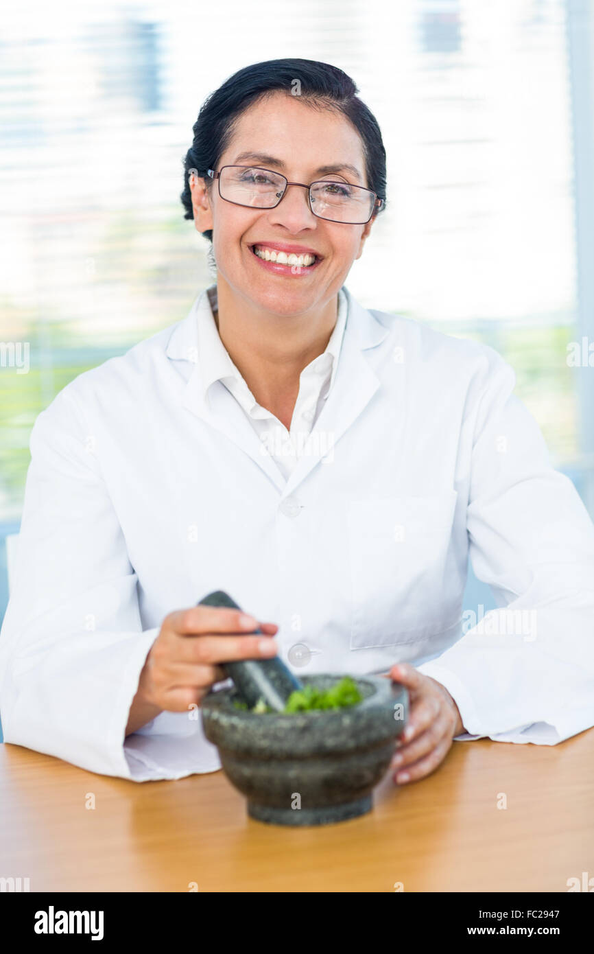 Scientist mixing herbs with pestle and mortar Stock Photo - Alamy