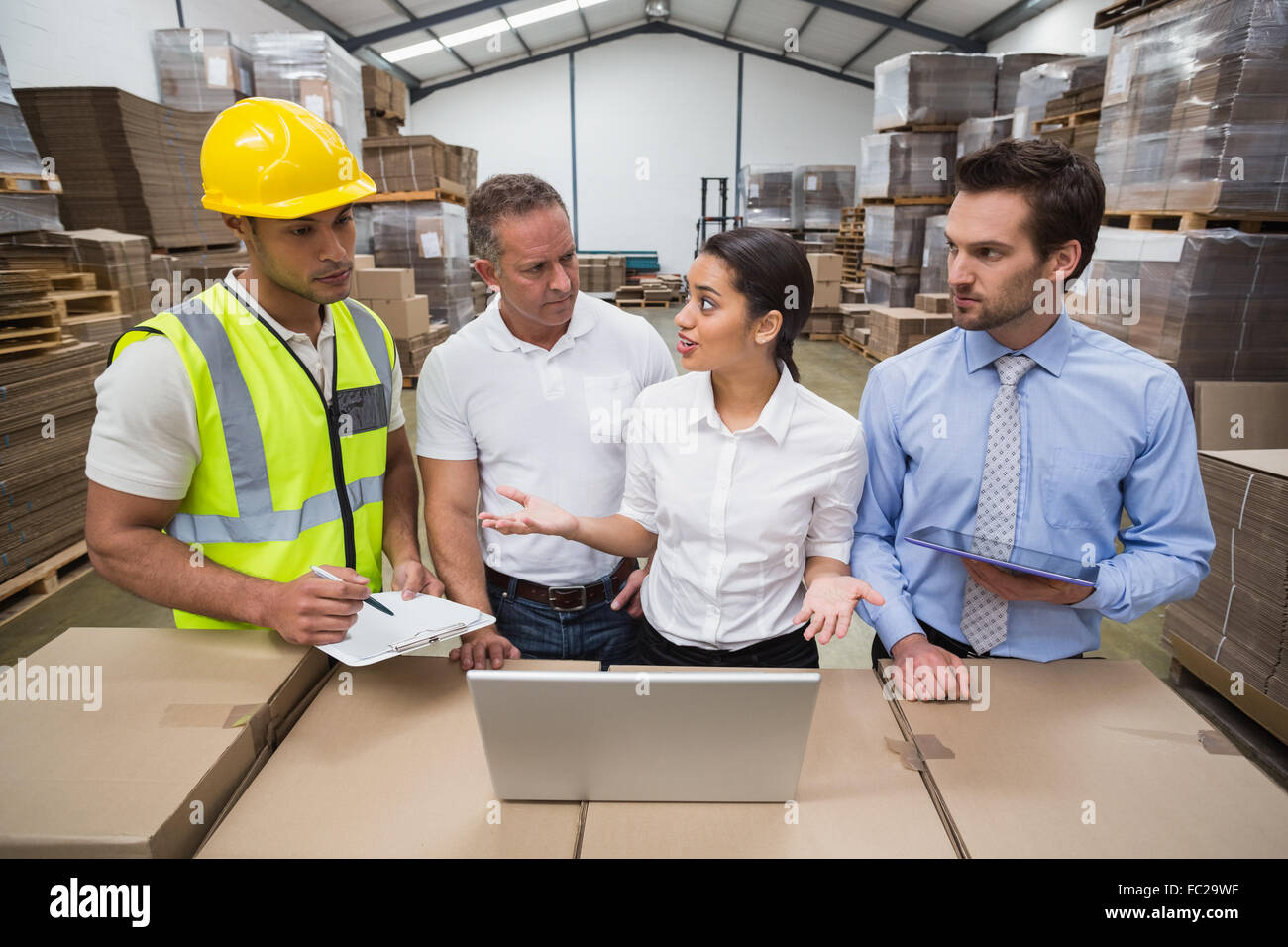 Warehouse managers and worker talking together Stock Photo - Alamy