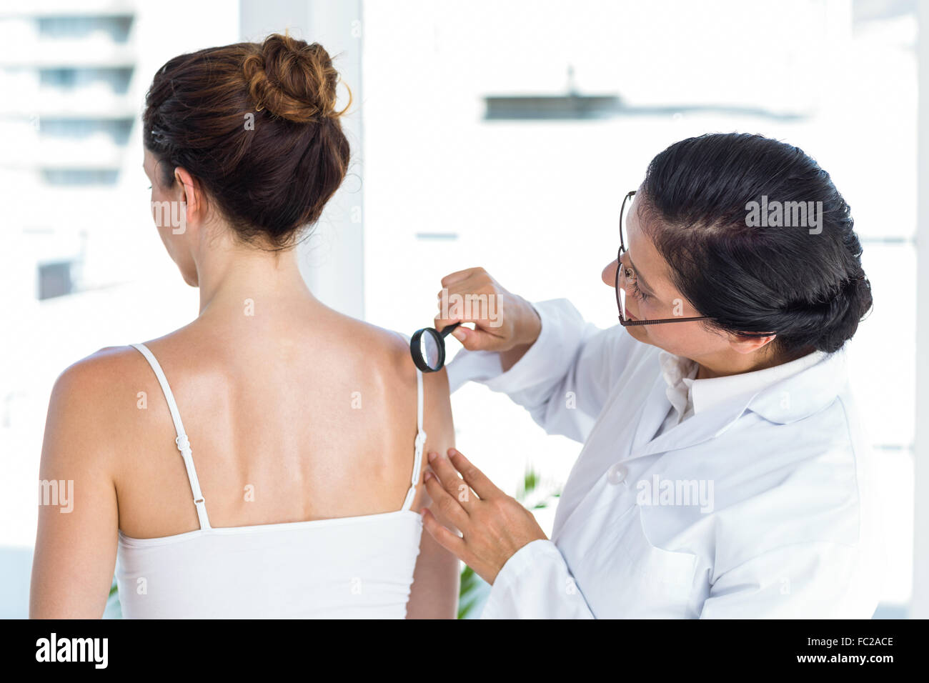 Doctor examining patient with magnifying glass Stock Photo - Alamy