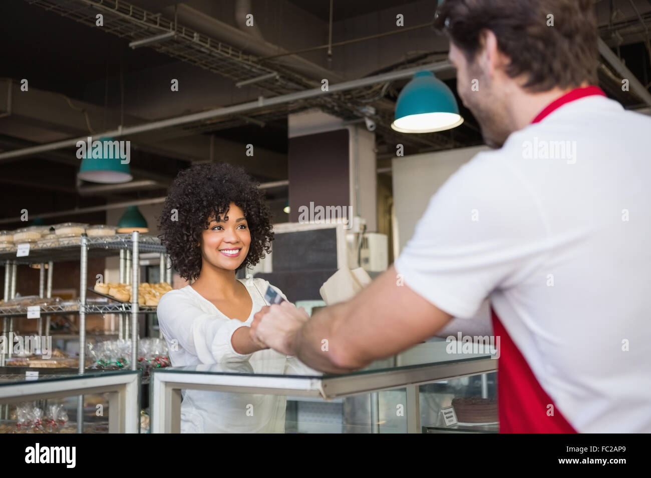 Smiling waiter doing transaction with customer Stock Photo - Alamy