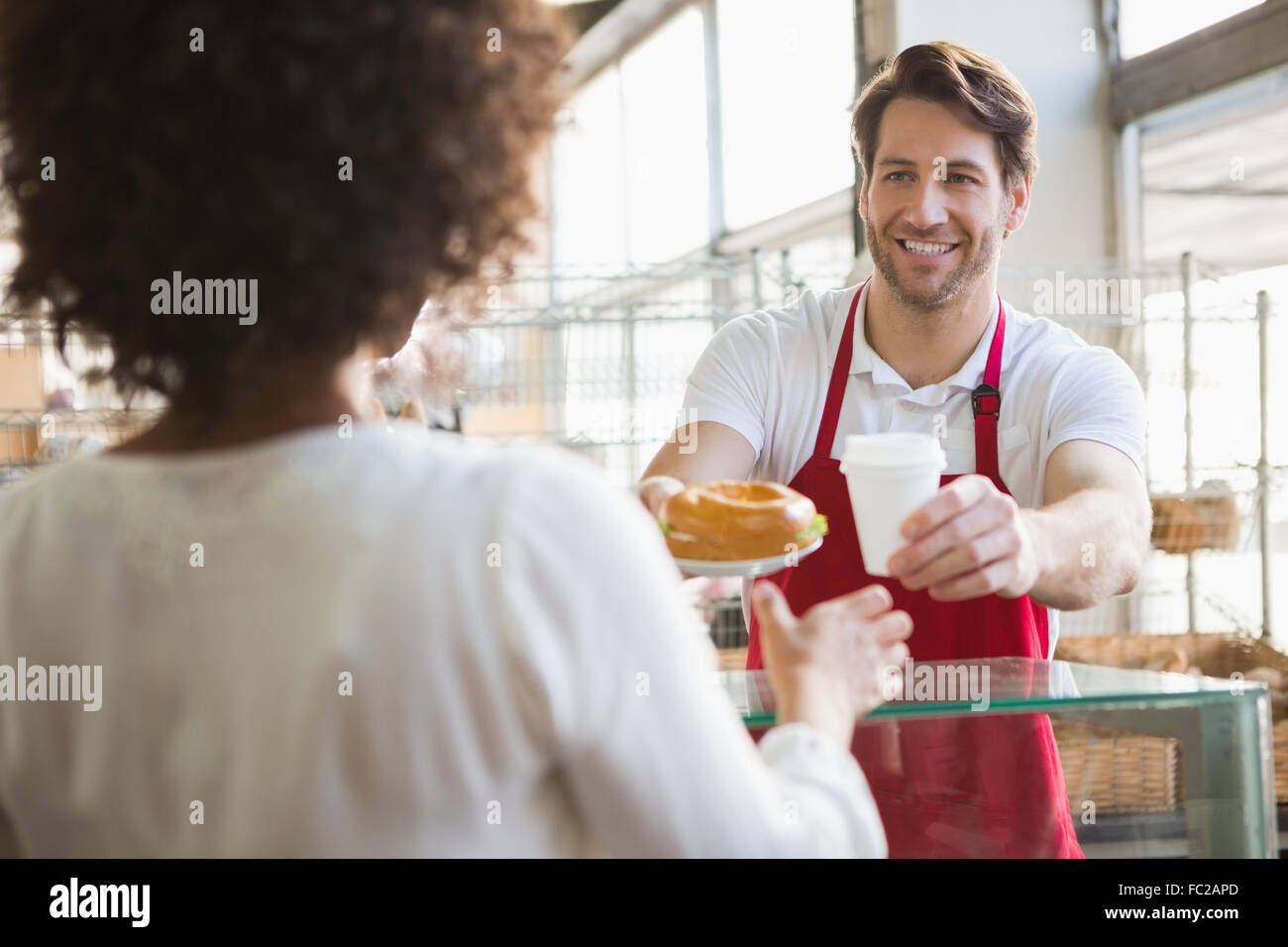 Smiling waiter giving lunch and hot drink to customer Stock Photo - Alamy