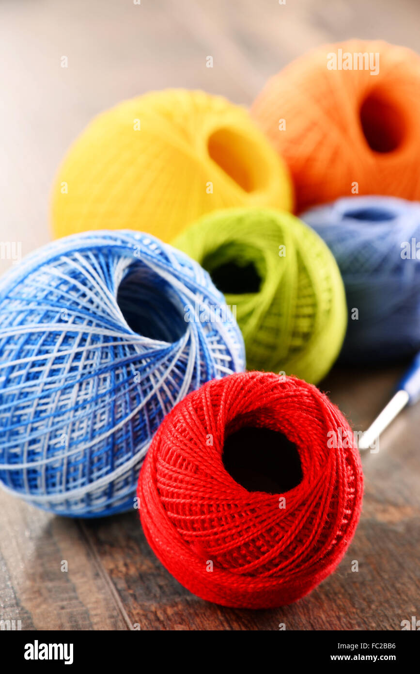 Colorful yarn for crocheting and hook on wooden table Stock Photo - Alamy