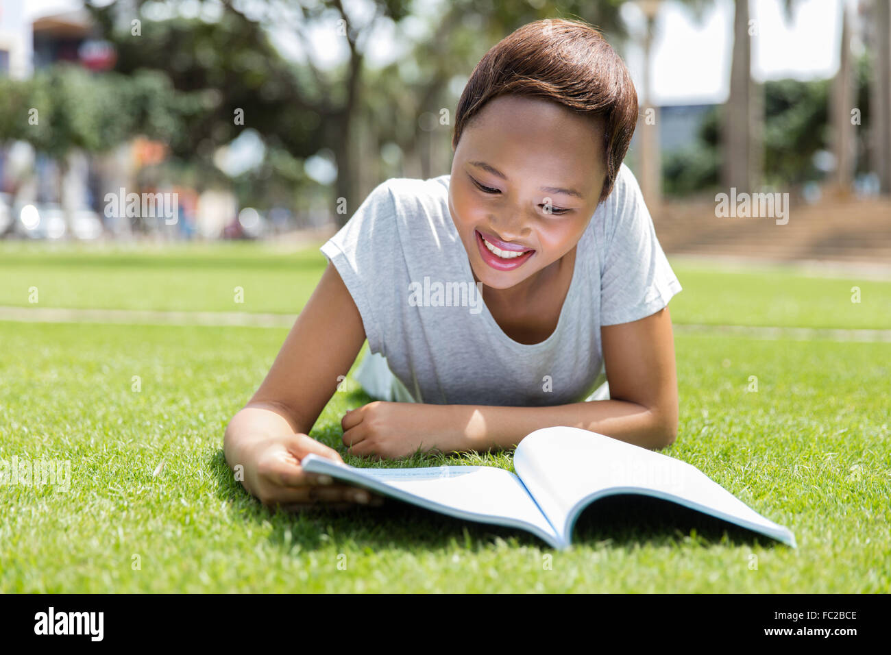 Girl Laying In Grass Reading