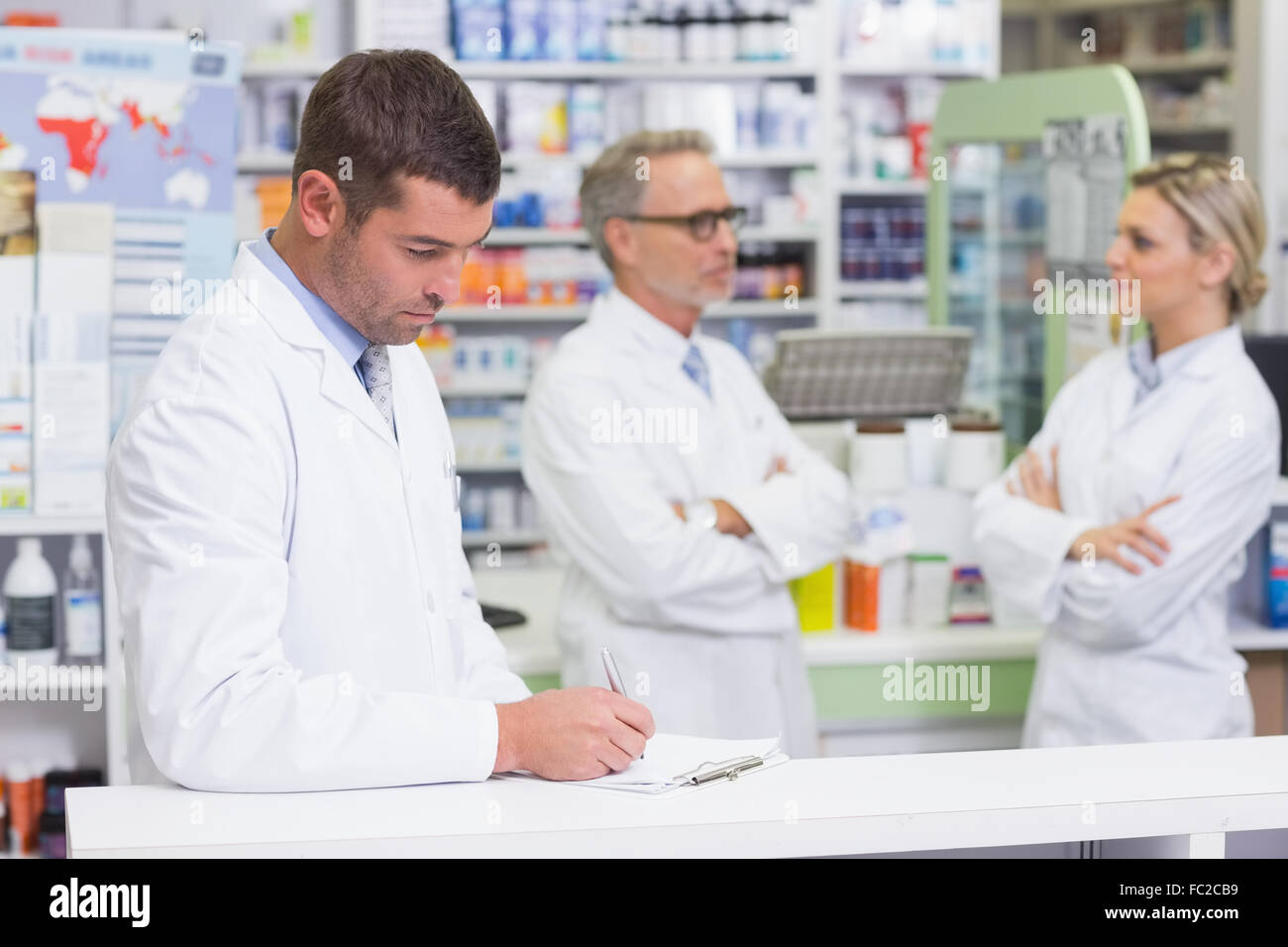 Pharmacist in lab coat writing a prescription Stock Photo - Alamy