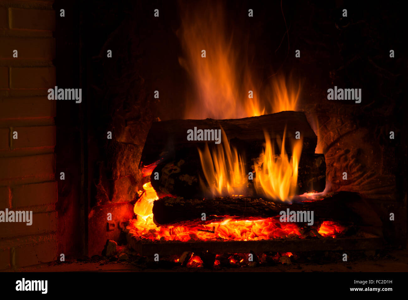 Burning fireplace with fresh firewood Stock Photo - Alamy