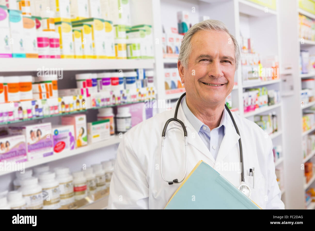 Smiling doctor with stethoscope holding notebooks Stock Photo - Alamy