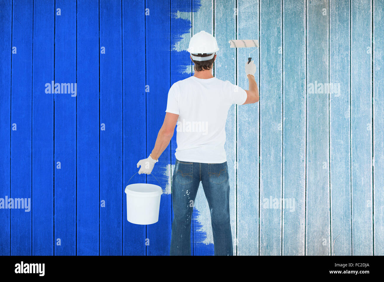 Composite image of rear view of man using paint roller Stock Photo - Alamy