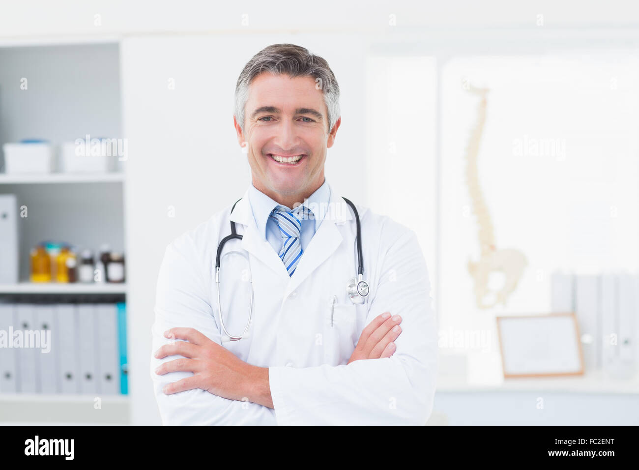 Confident doctor with arms crossed standing in clinic Stock Photo - Alamy