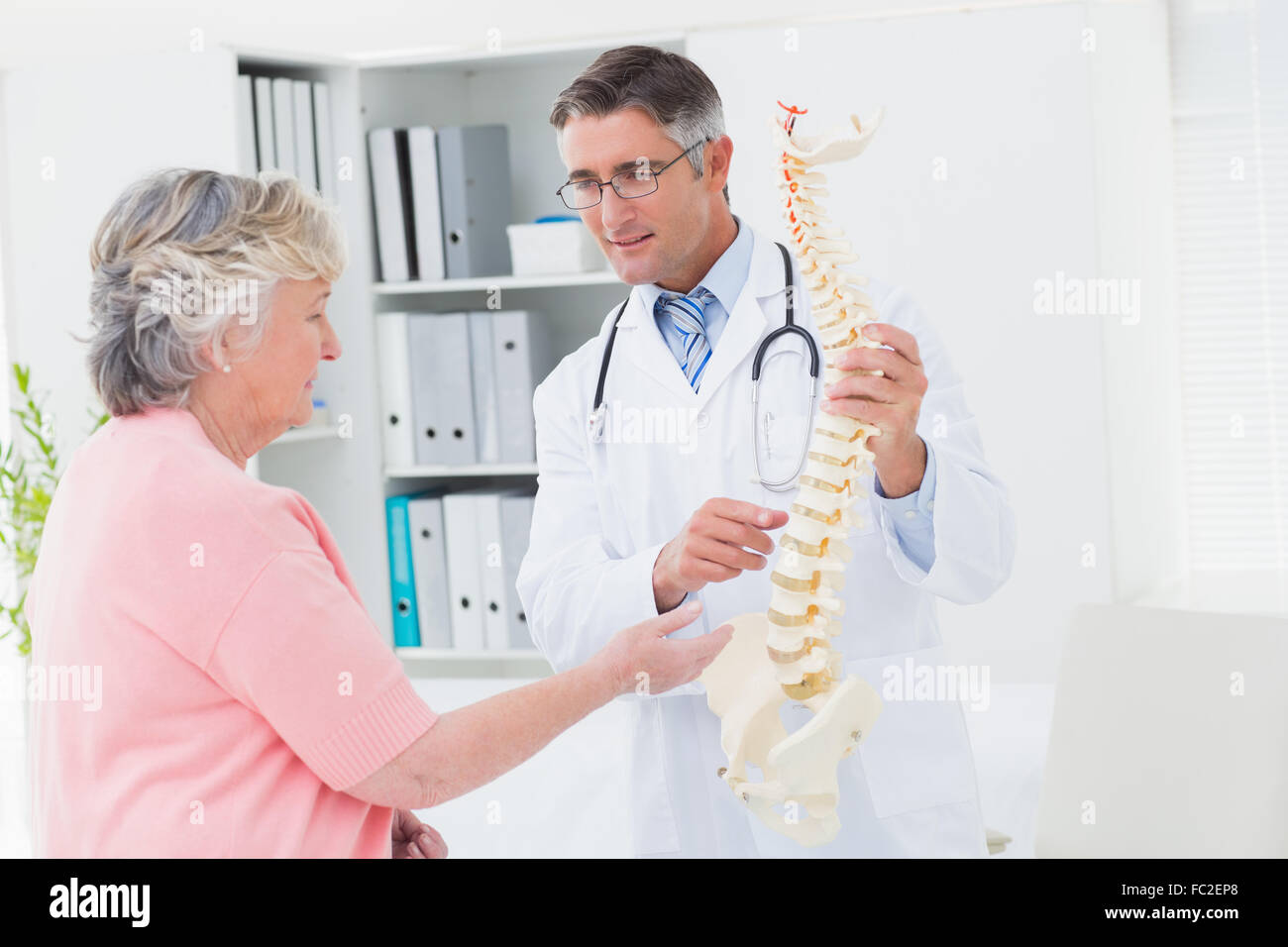Doctor and patient having discussion over anatomical spine Stock Photo ...