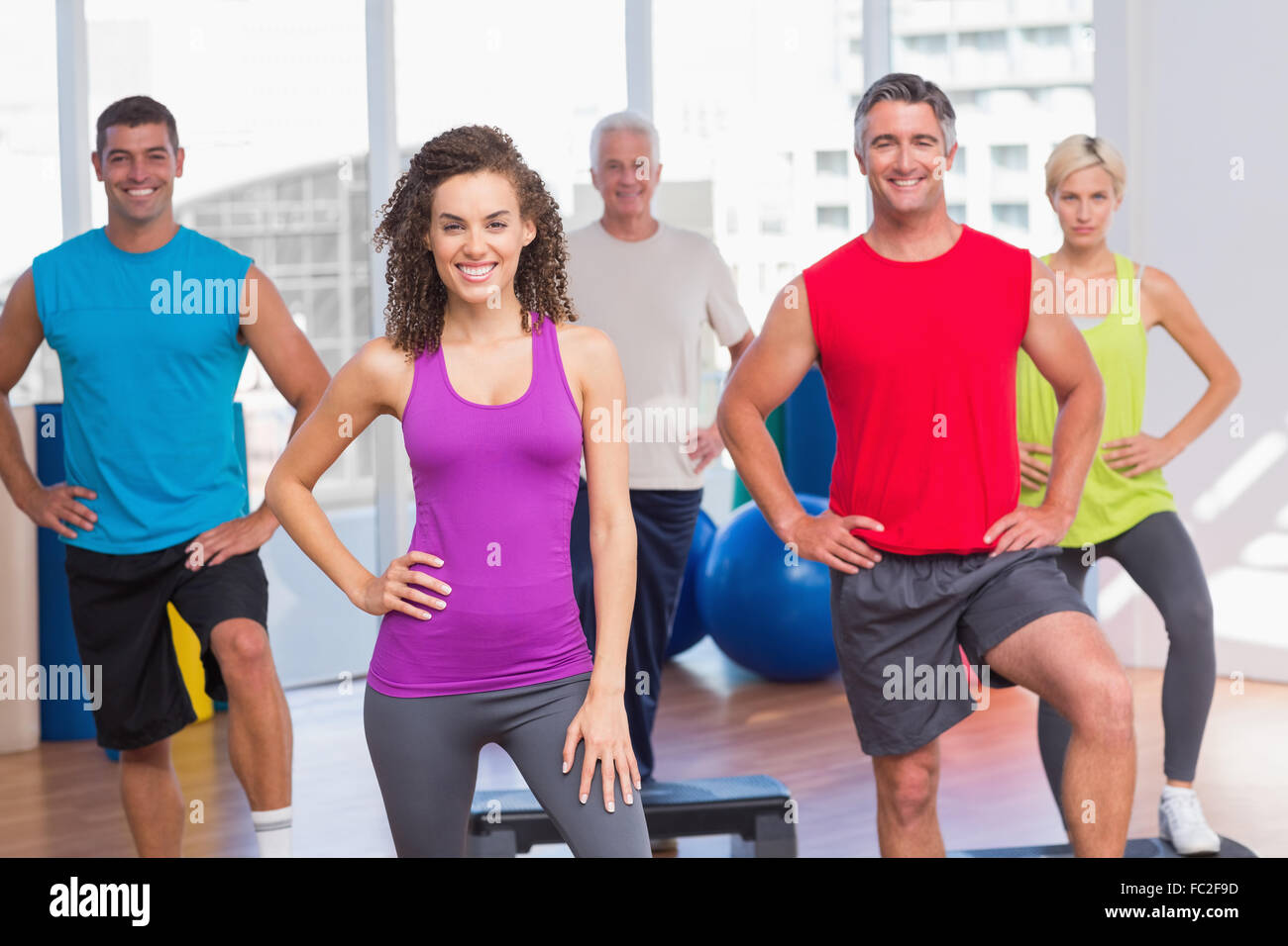 Instructor with fitness class performing step aerobics exercise Stock ...