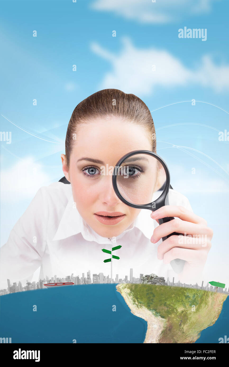 Composite image of businesswoman typing and looking through magnifying ...