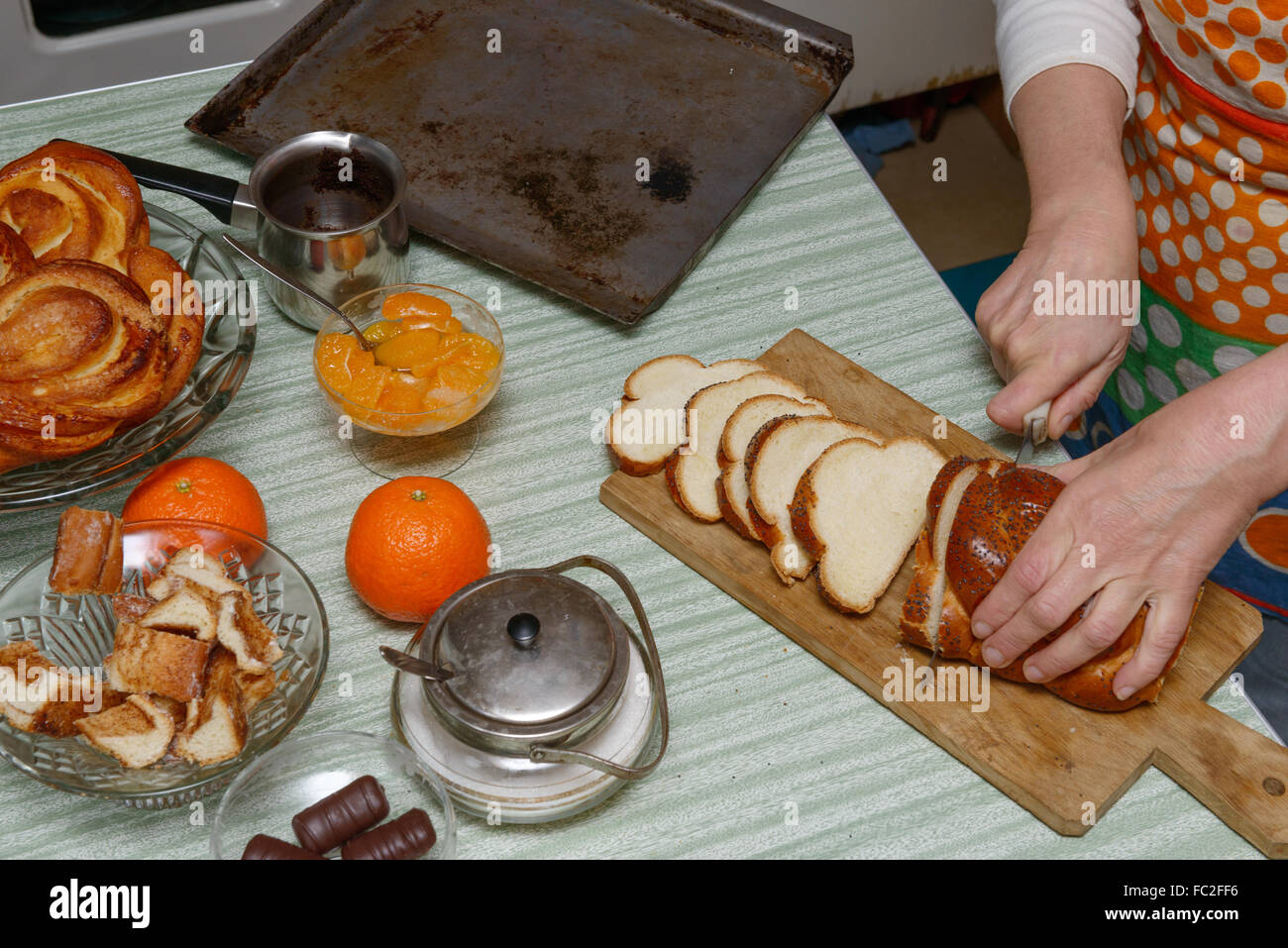Top of cook table with hands of woman that slicing fancy bread challah ...
