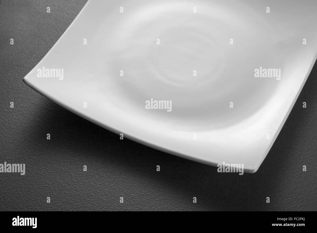 Empty white plate on black background Stock Photo - Alamy