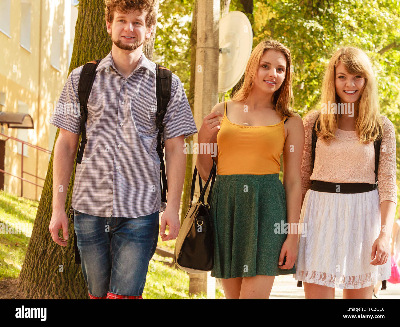 Three people friends walking outdoor. Fashion women and man relaxing ...
