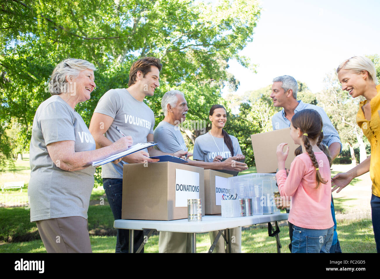 Happy volunteer family separating donations stuffs Stock Photo - Alamy
