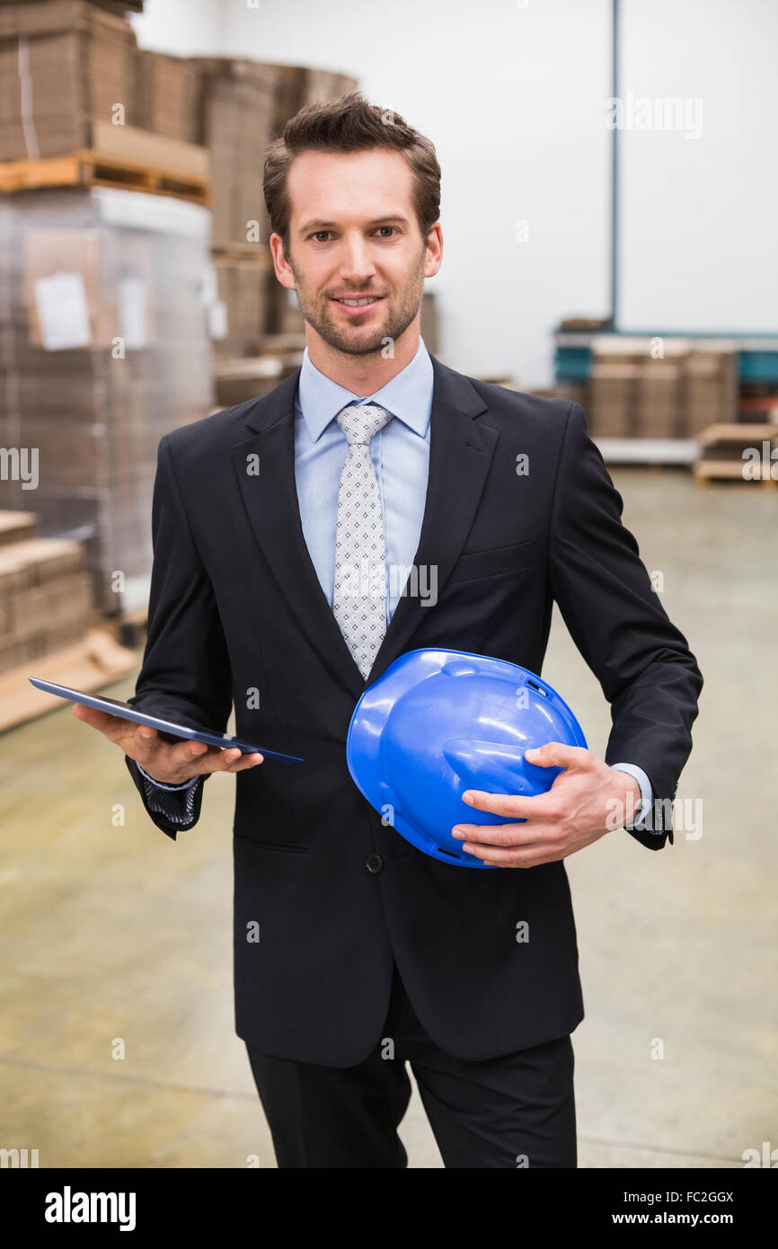 Warehouse manager holding tablet and hard hat Stock Photo - Alamy