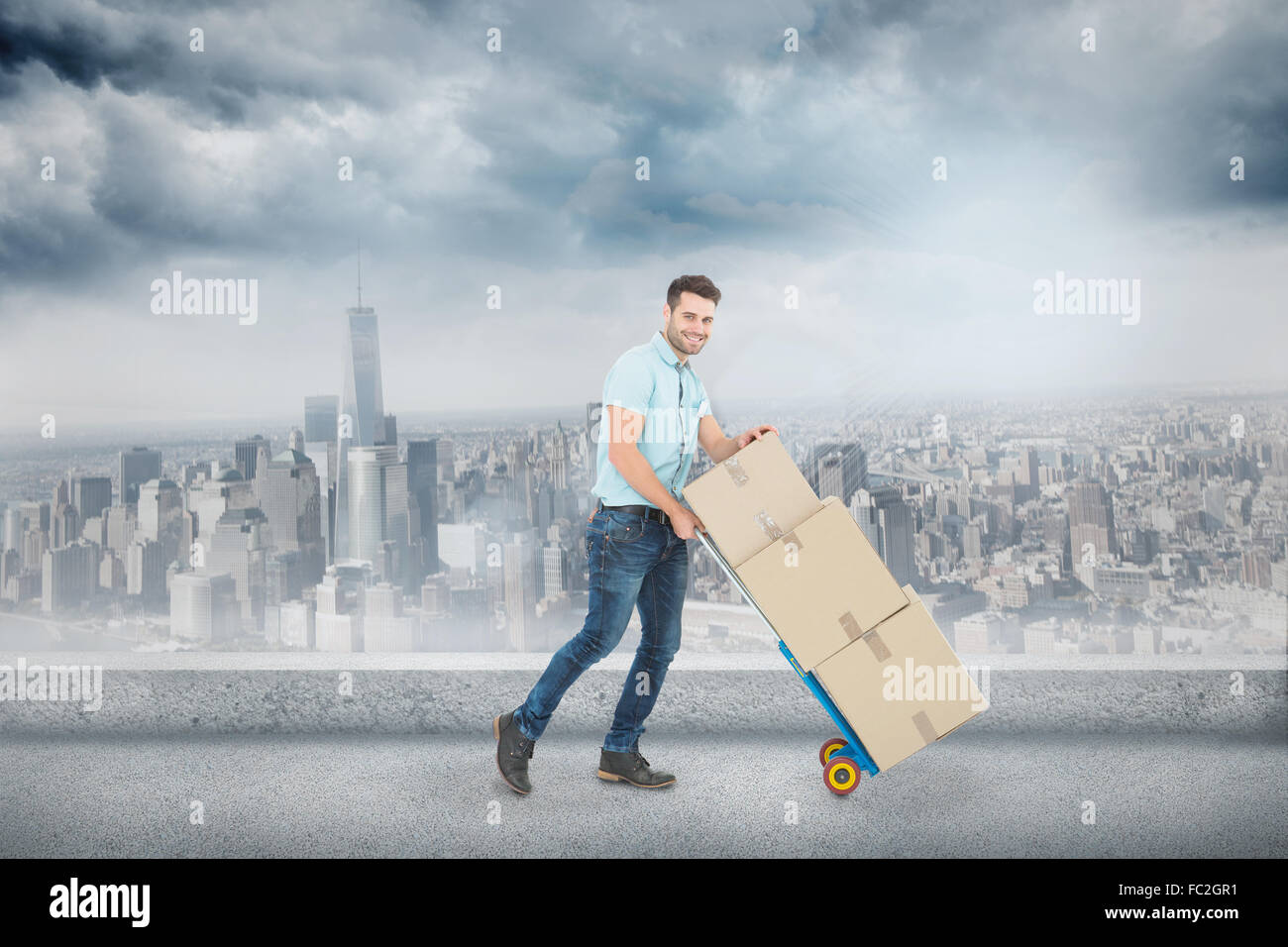 Composite image of happy delivery man pushing trolley of boxes Stock ...