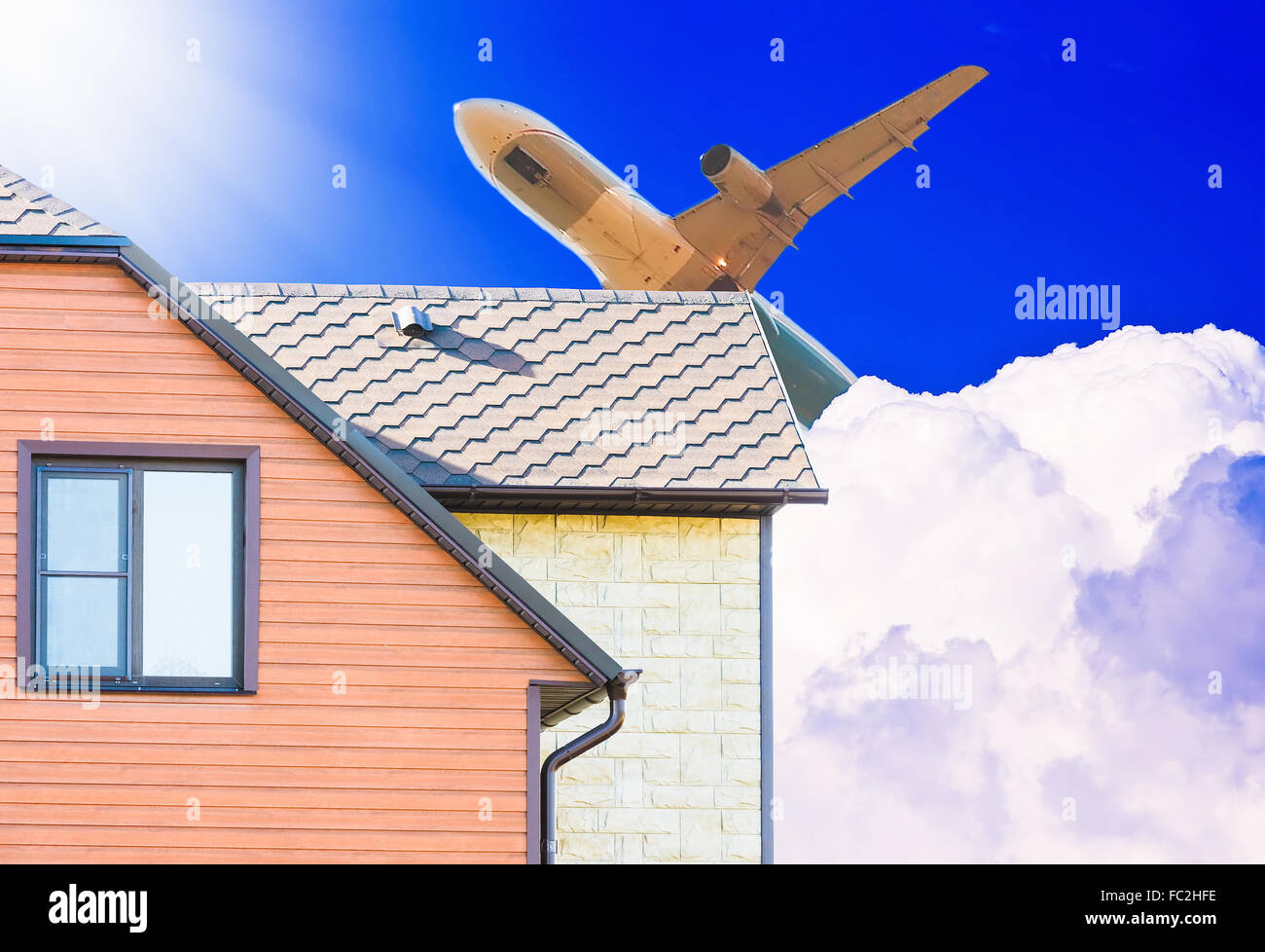 aircraft flies over the roof of the house Stock Photo - Alamy