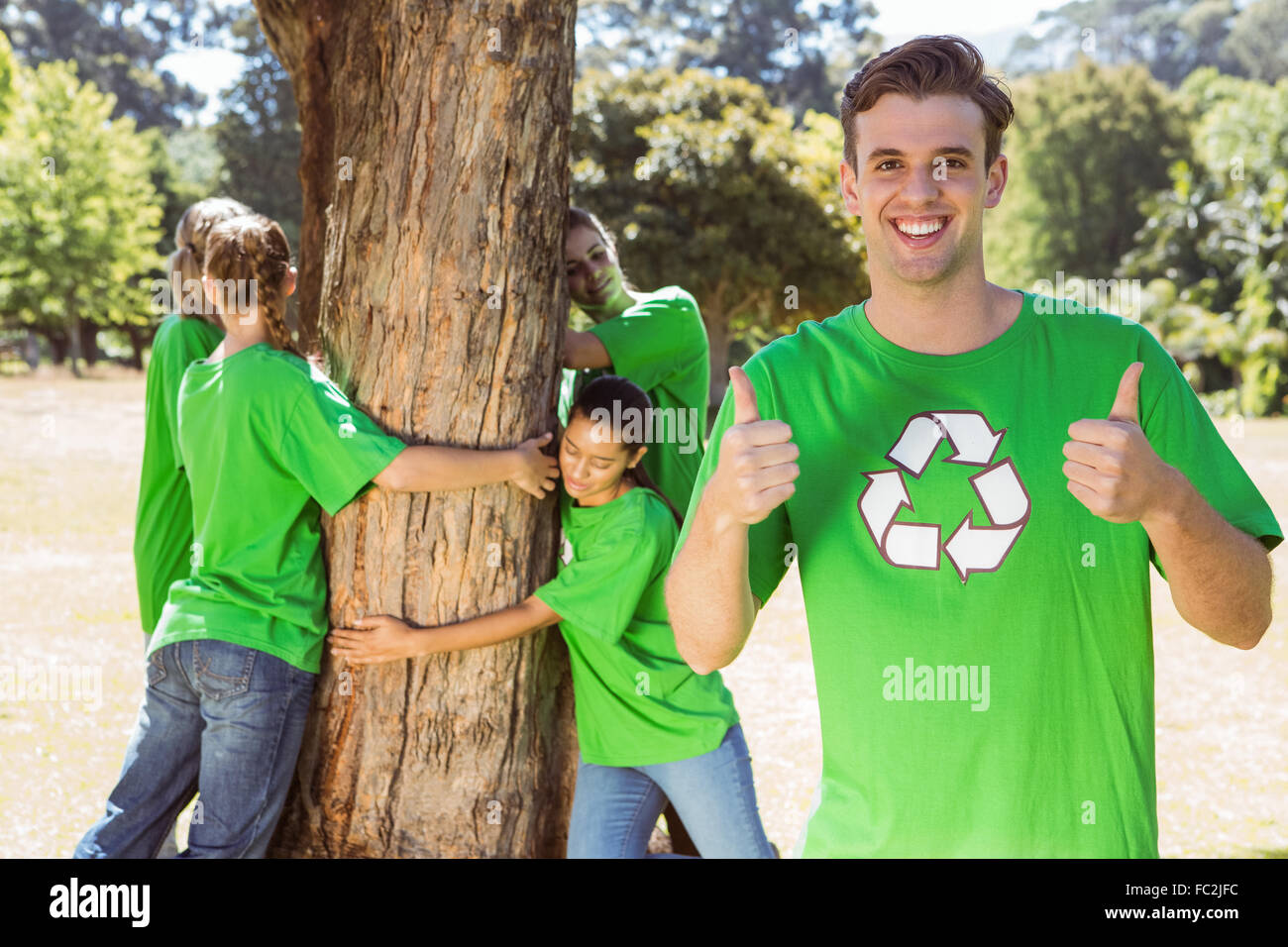 Environmental activists hugging a tree in the park Stock Photo - Alamy