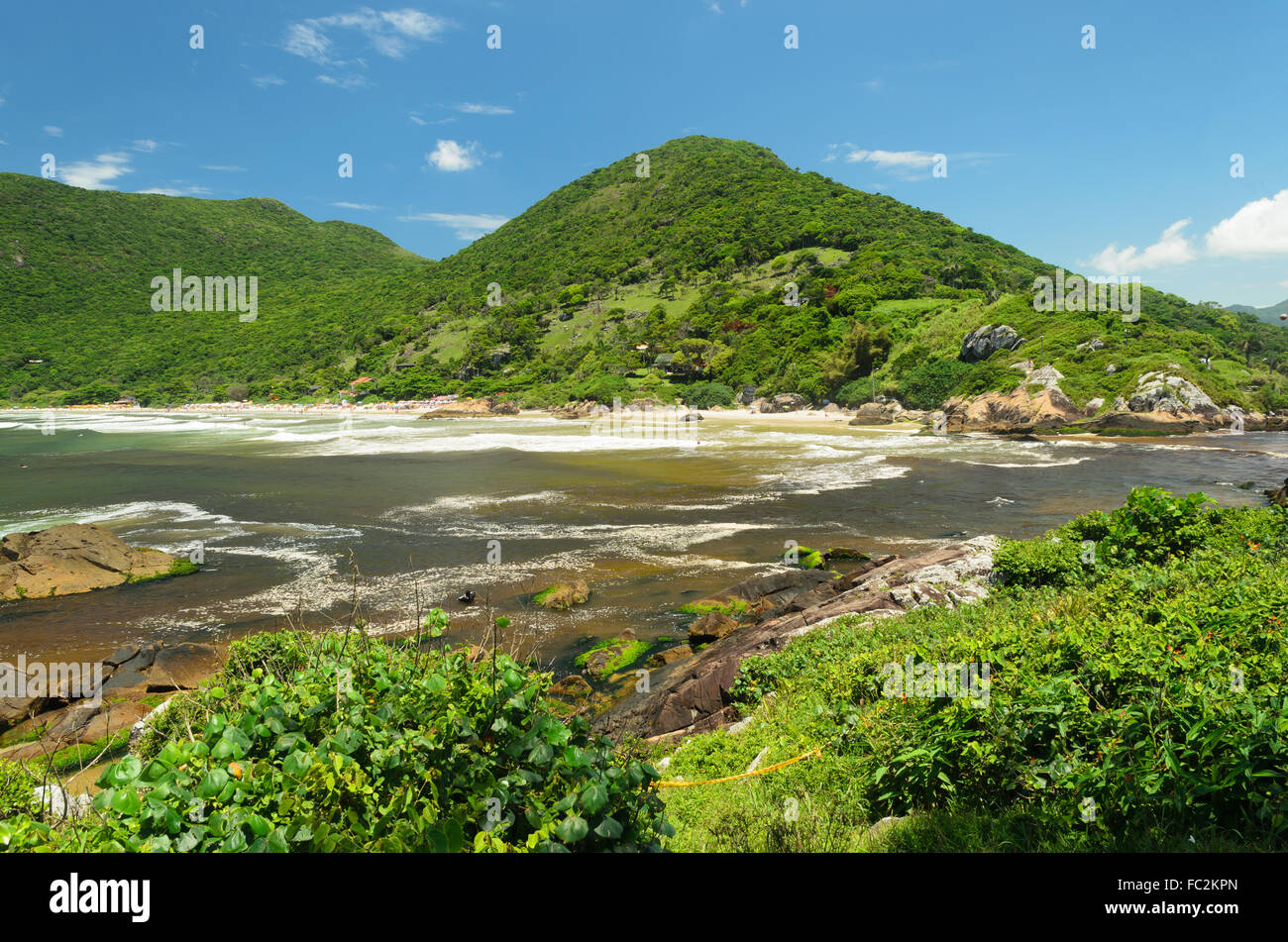 view of a beach and sky with mountains in the background in ...
