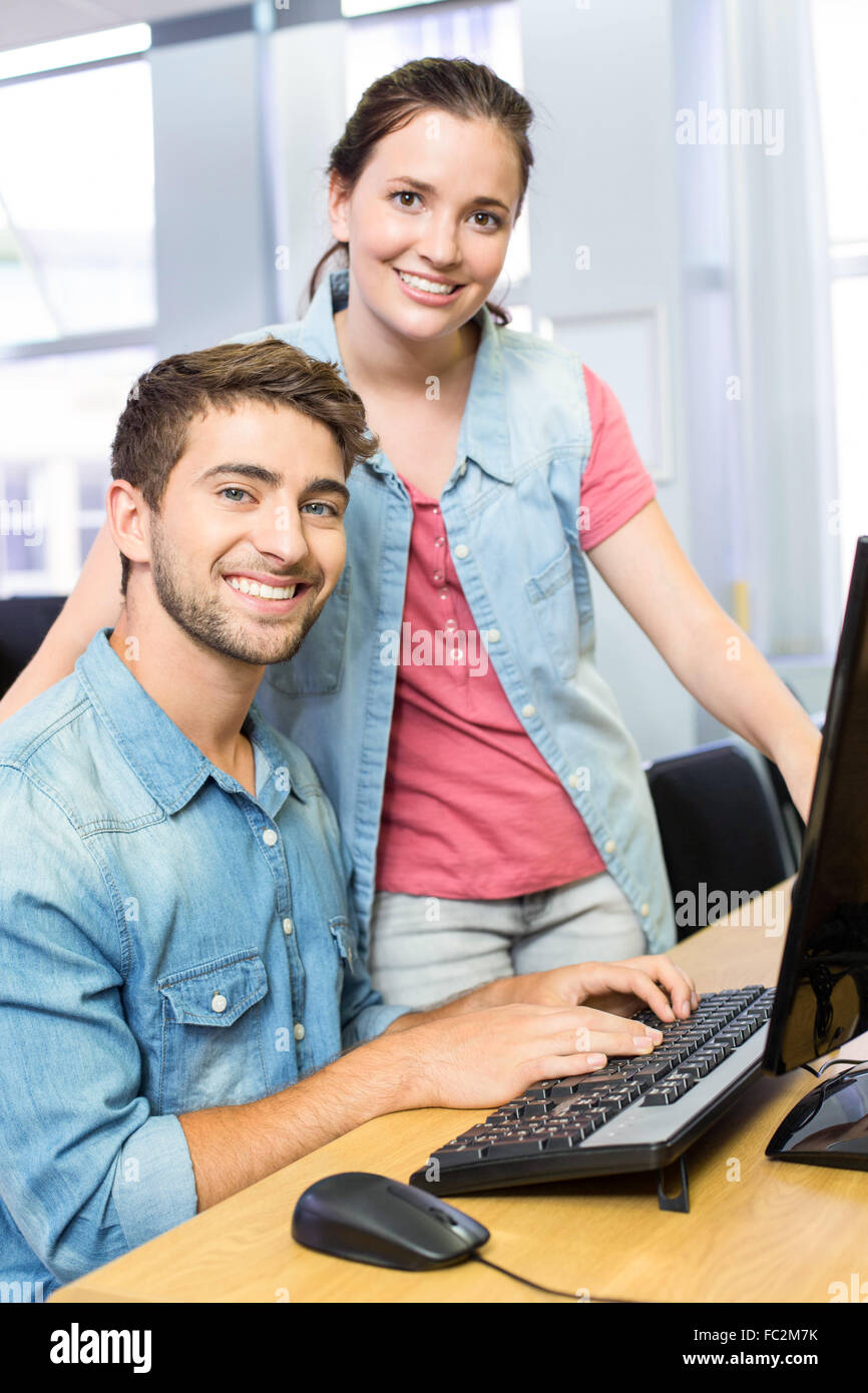 Computer teacher helping pretty female student Stock Photo - Alamy