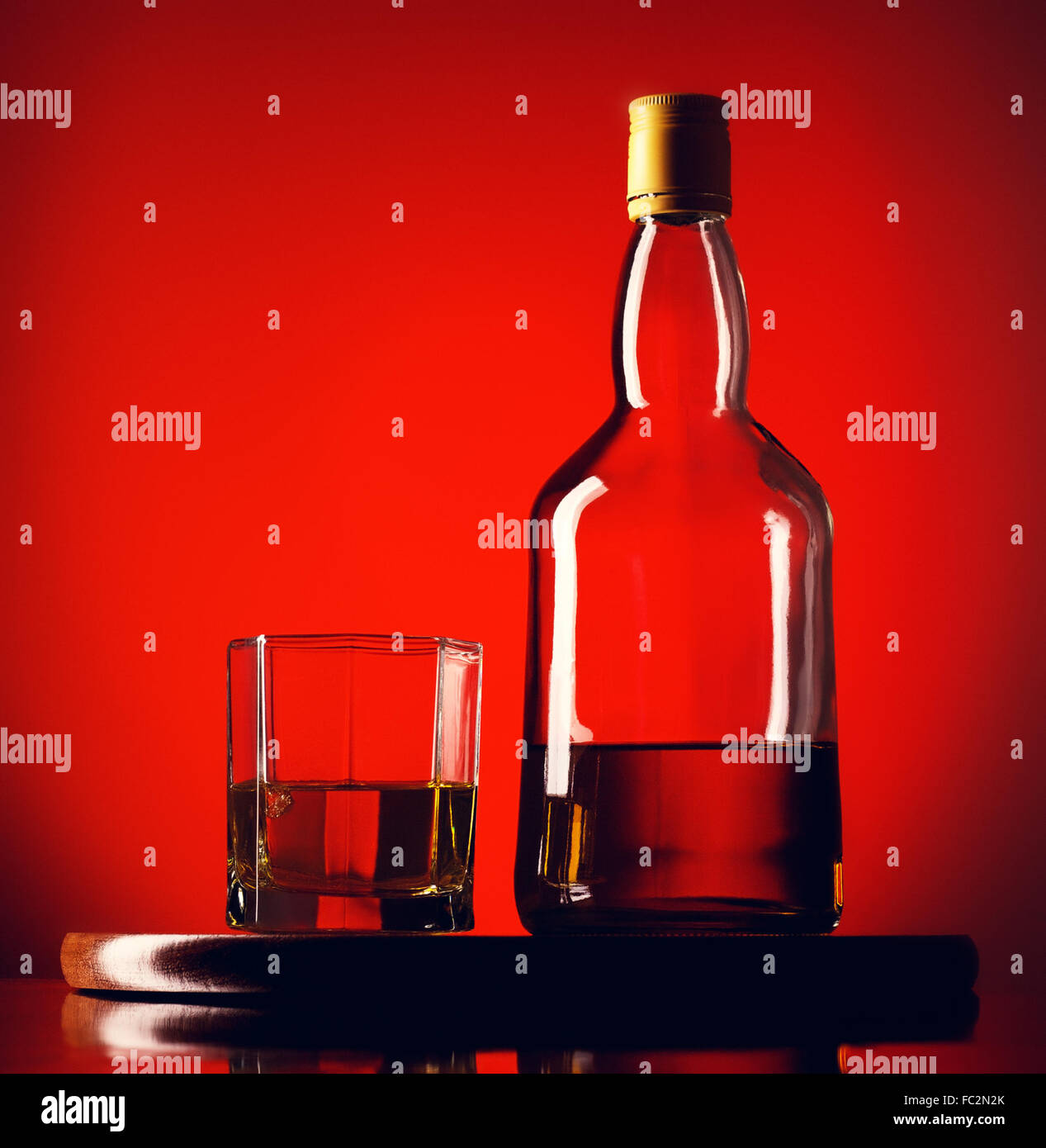 glass and bottle of whiskey on a red background Stock Photo - Alamy